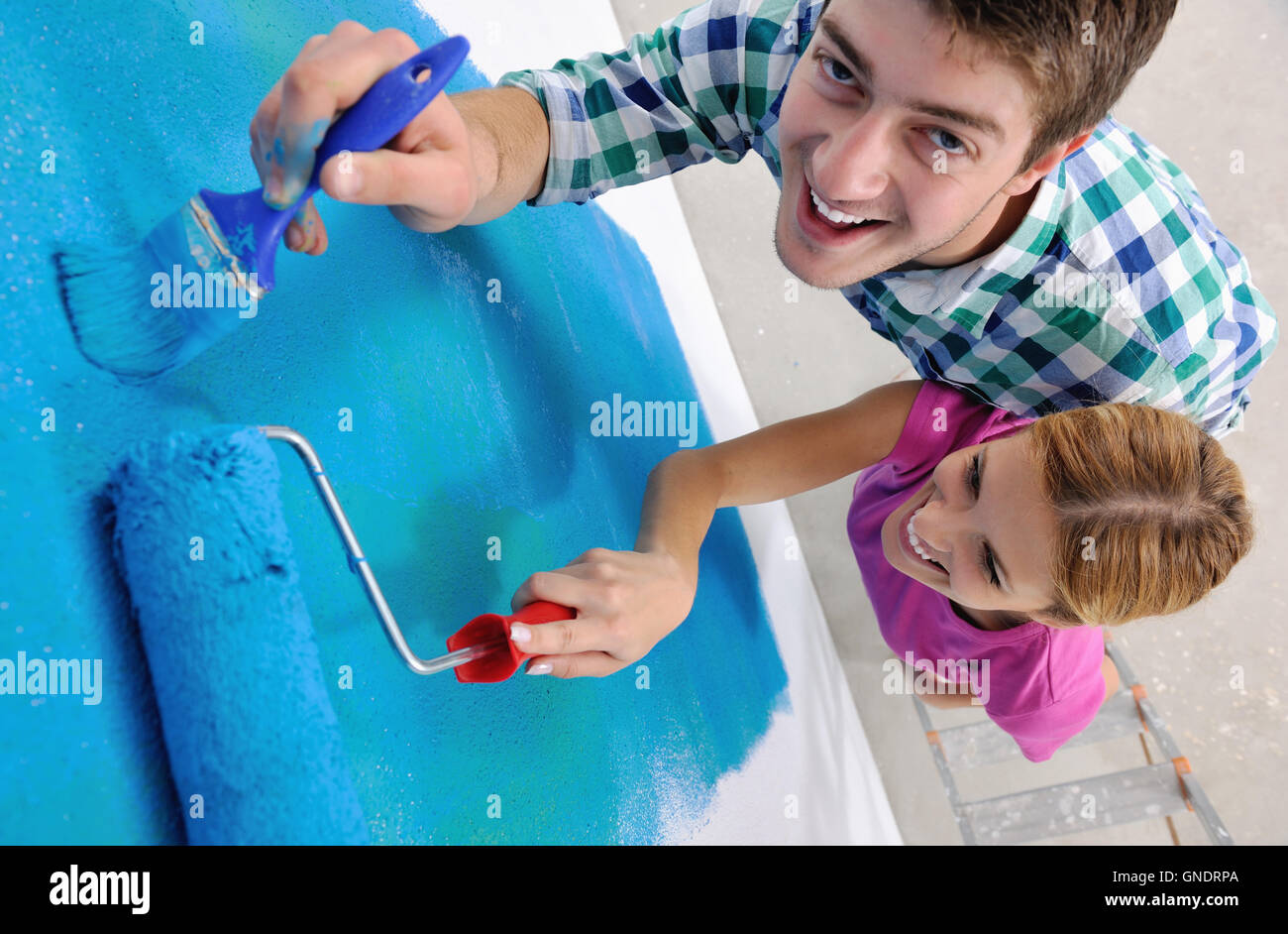 happy couple paint wall at new home Stock Photo - Alamy