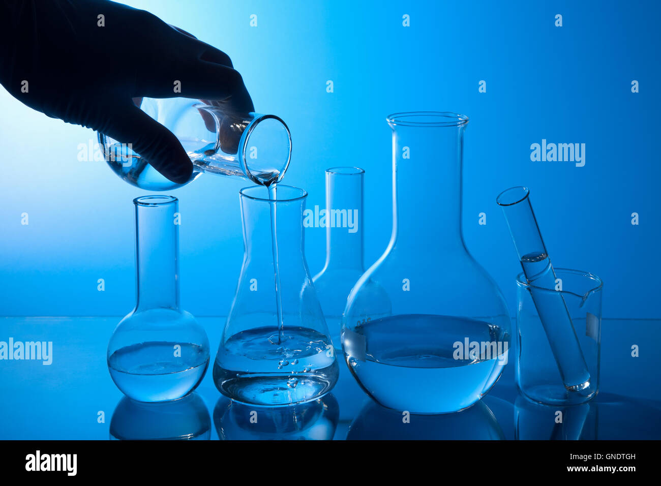 hand pouring liquid into flask Stock Photo - Alamy