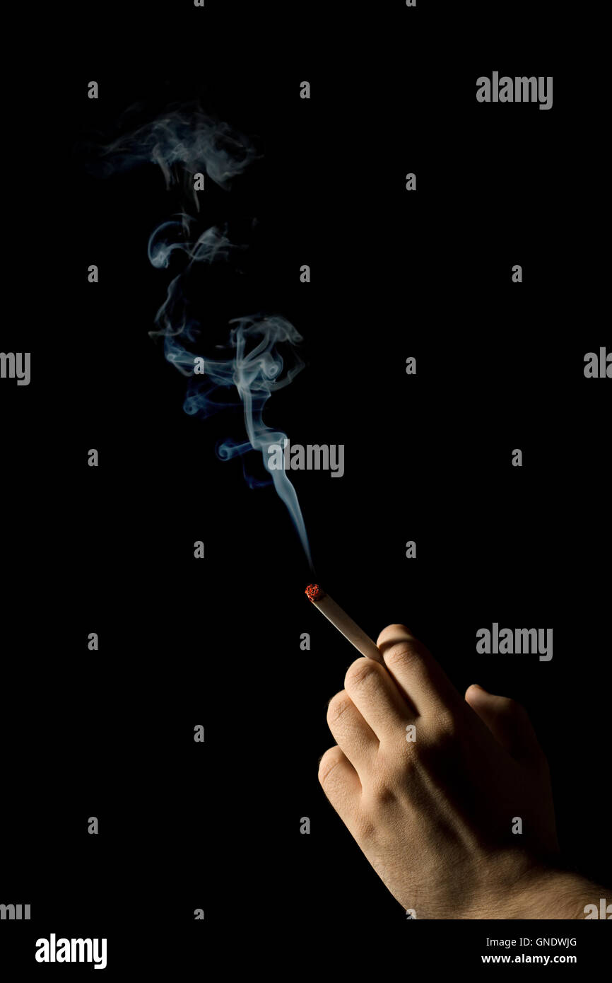 hand holding a smoking cigarette isolated Stock Photo - Alamy