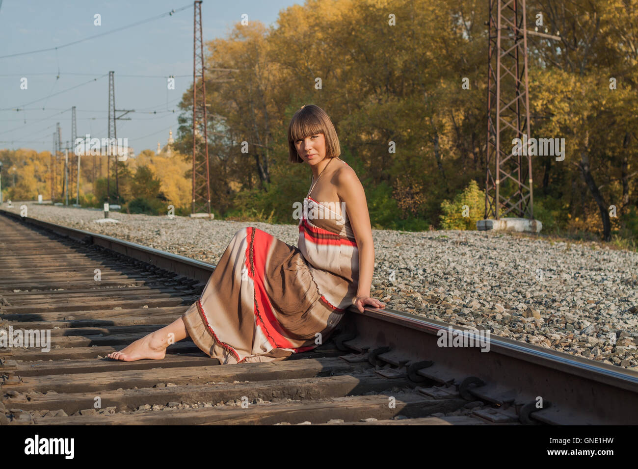 Beautiful girl sitting on railroad track Stock Photo - Alamy