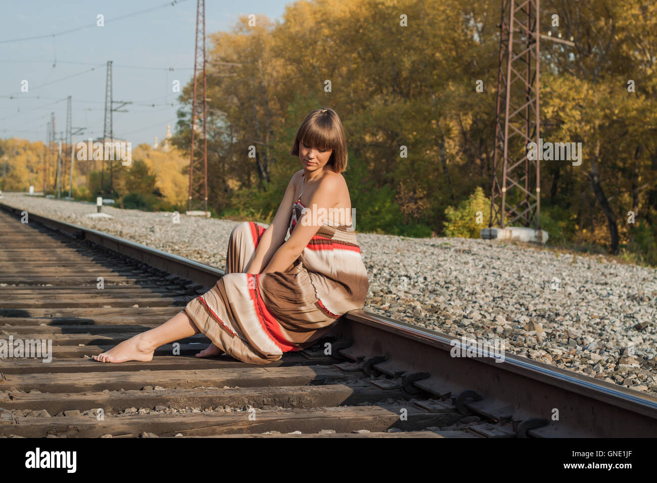 Beautiful girl sitting on railroad track Stock Photo - Alamy