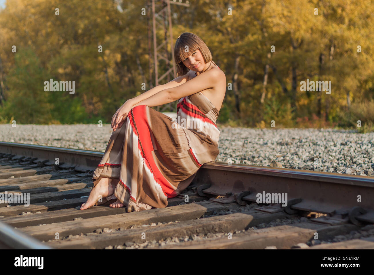 Beautiful girl sitting on railroad track Stock Photo - Alamy