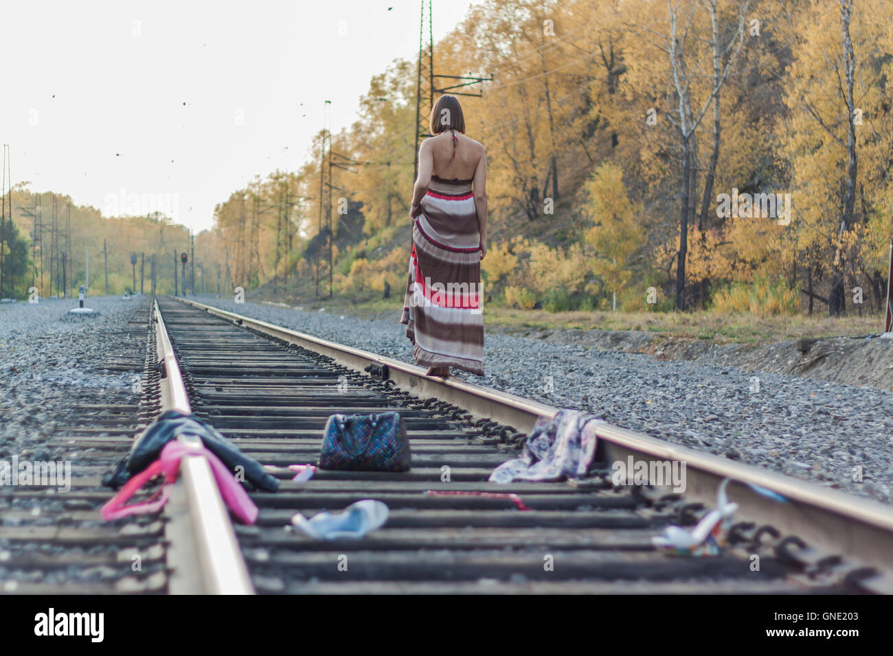 Beautiful girl walking on railroad track Stock Photo - Alamy