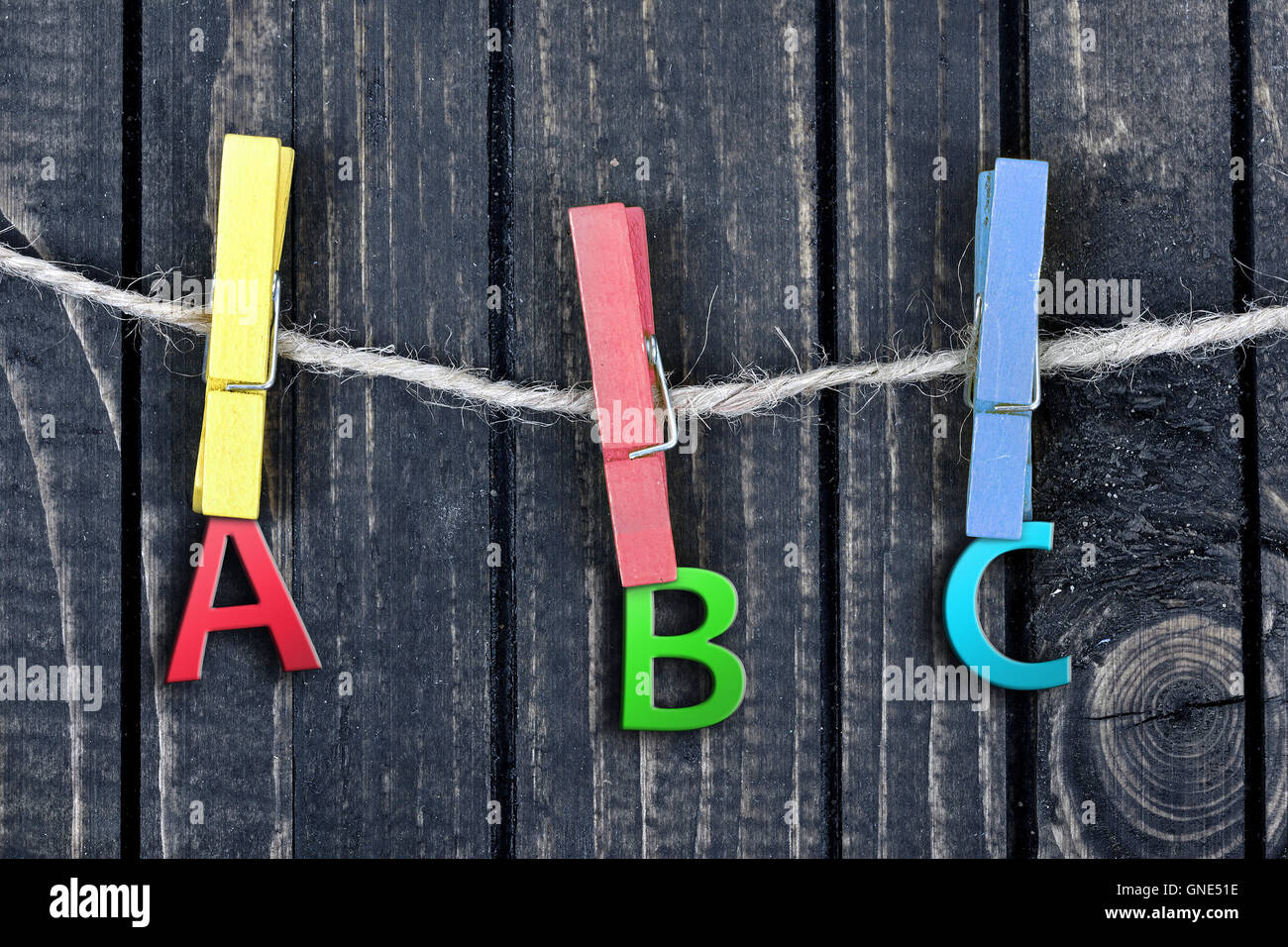 ABC word hanging on clips and wooden wall Stock Photo - Alamy