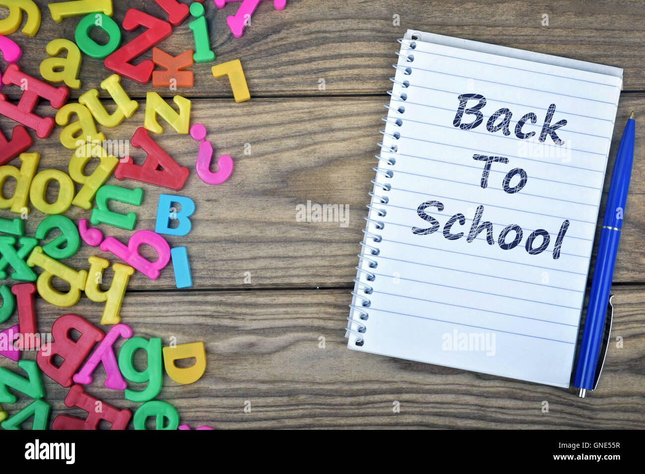 Back to School text on notepad and magnetic letters on wooden table ...