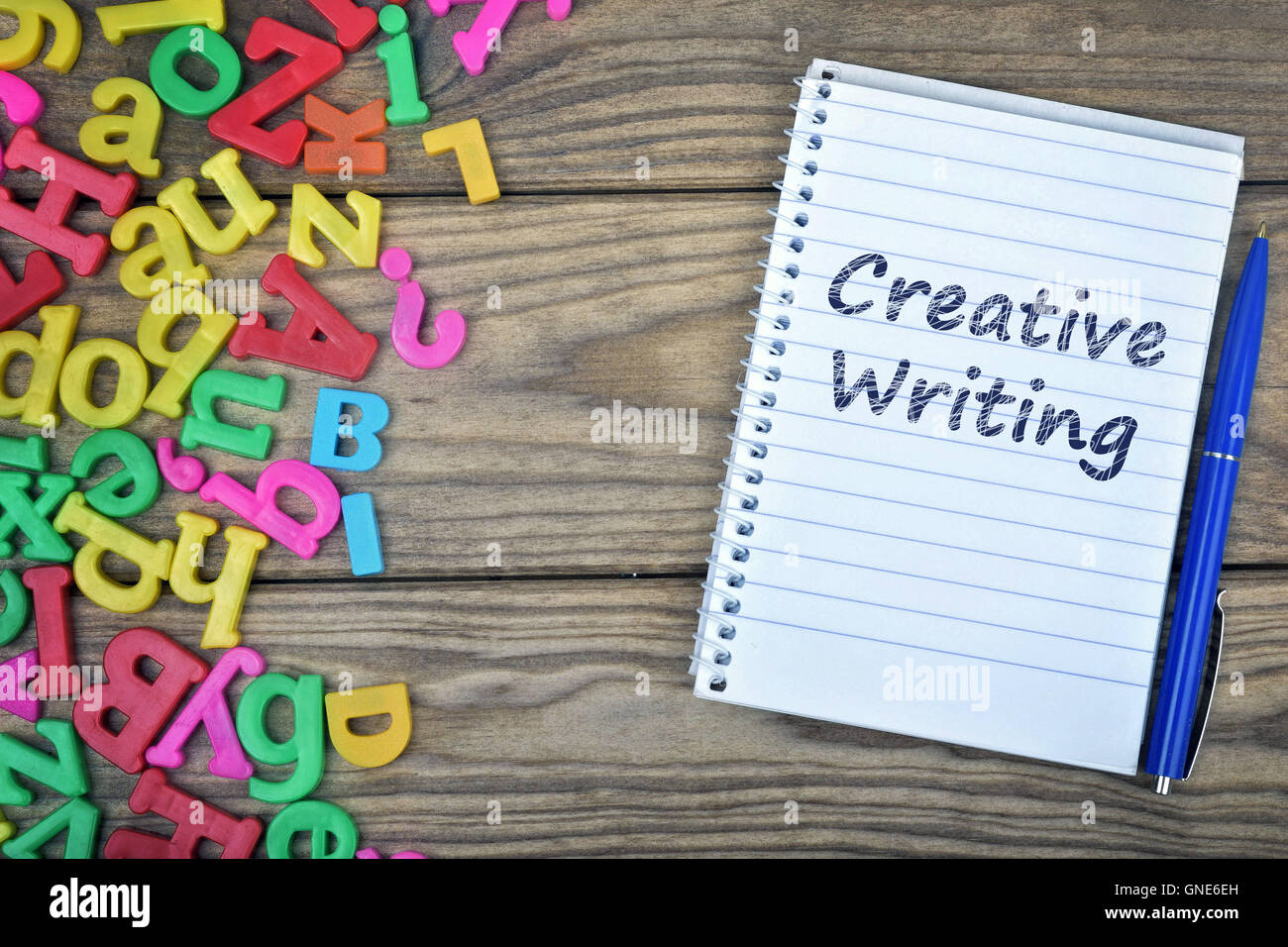 Creative Writing text on notepad and magnetic letters on wooden table ...