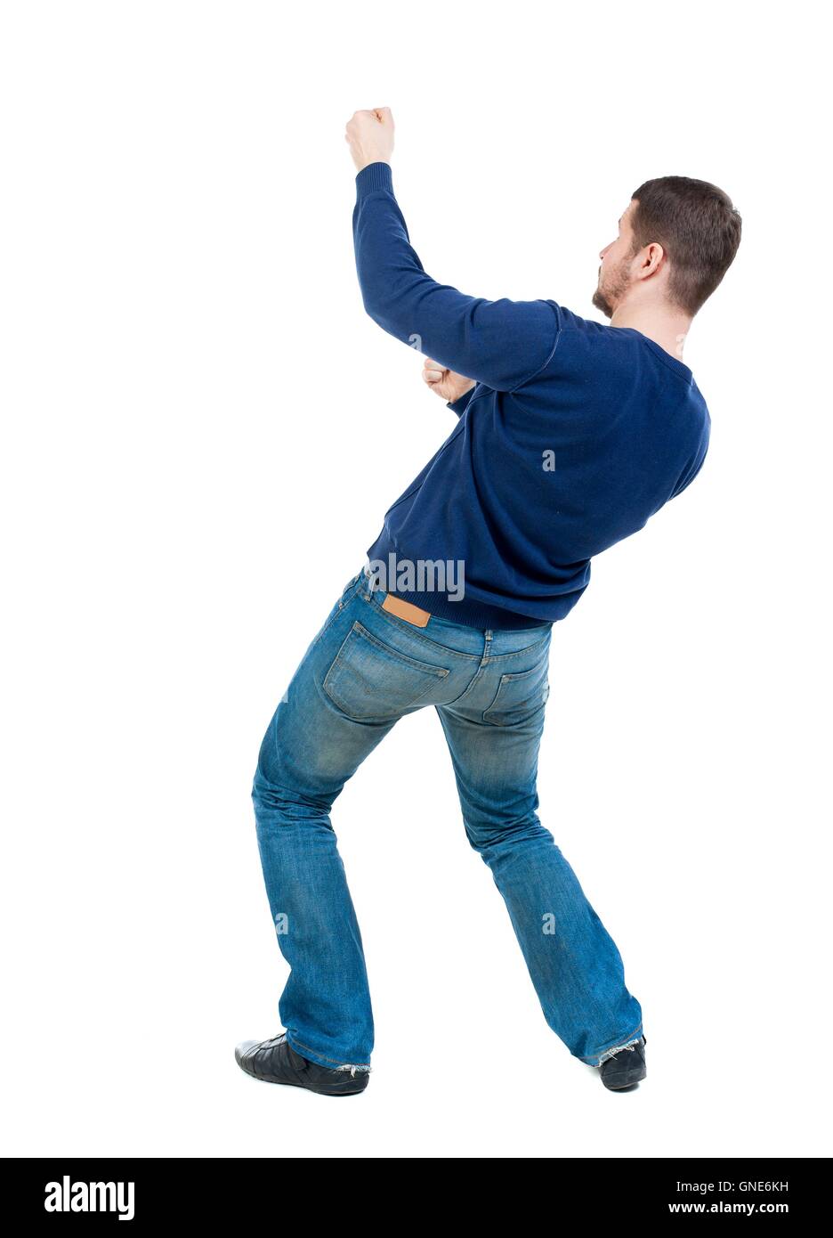 back view of standing man pulling a rope from the top or cling t Stock ...