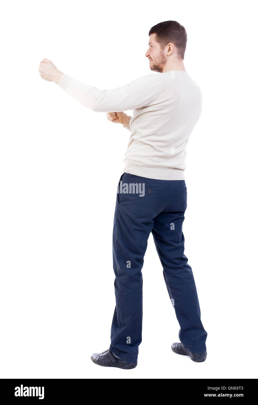 back view of standing man pulling a rope from the top or cling t Stock ...