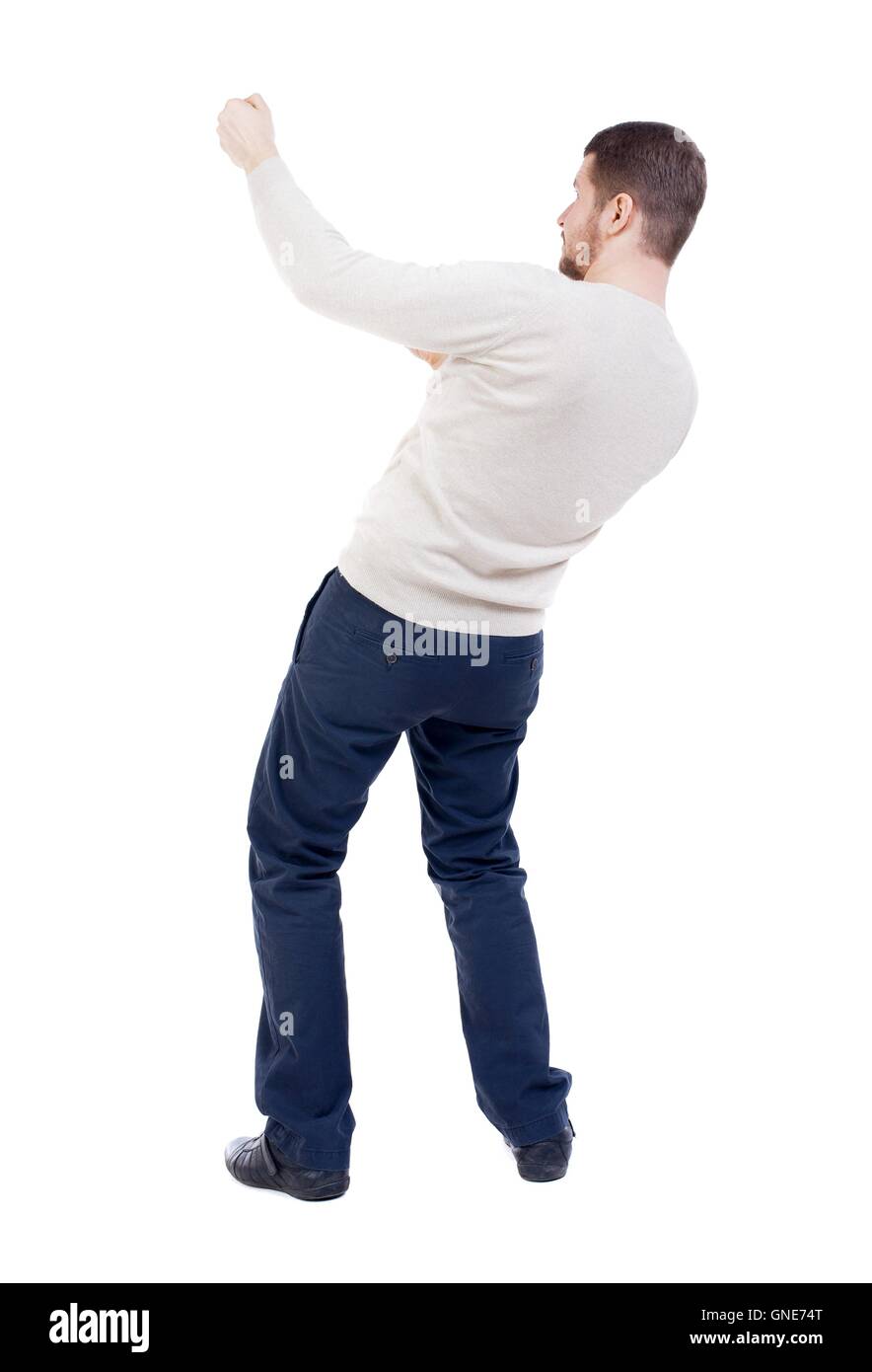 back view of standing man pulling a rope from the top or cling t Stock ...