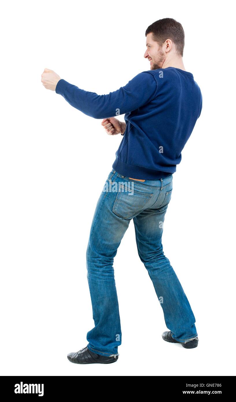 back view of standing man pulling a rope from the top or cling t Stock ...