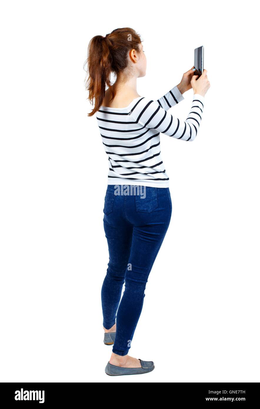back view of standing young beautiful woman using a mobile pho Stock ...
