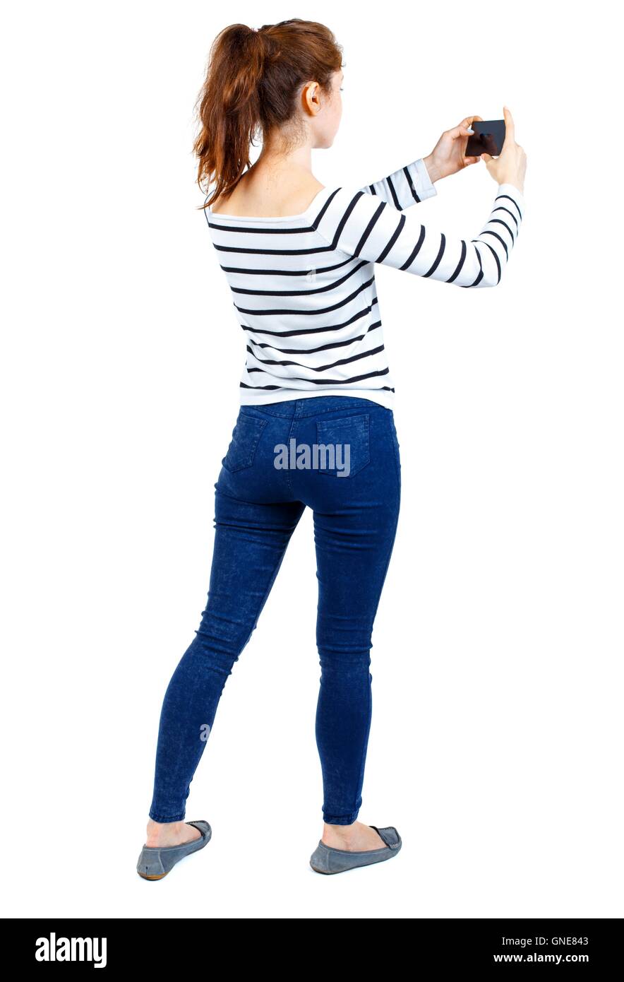 back view of standing young beautiful woman using a mobile pho Stock ...