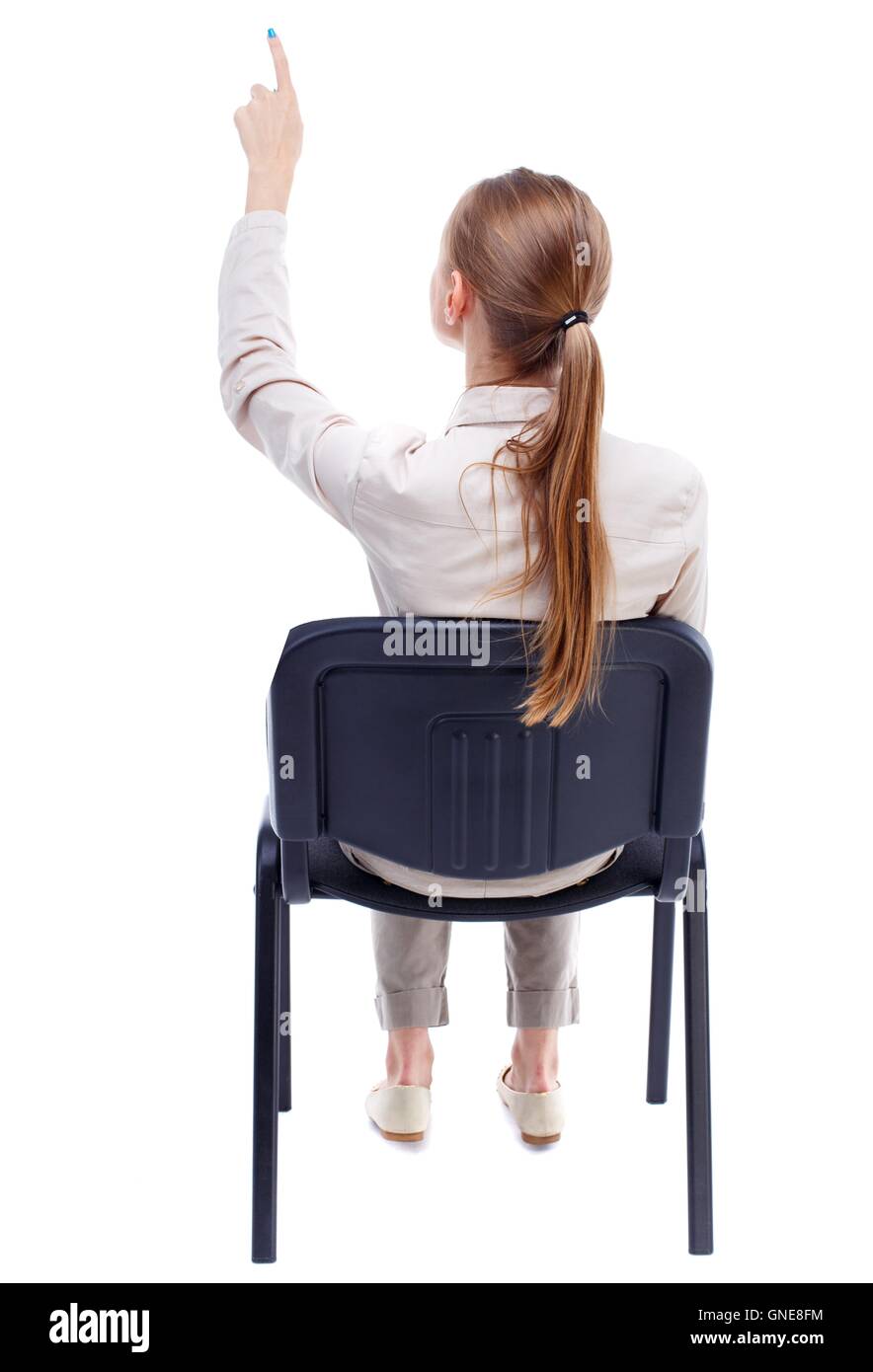 back view of young beautiful woman sitting on chair and pointin Stock ...