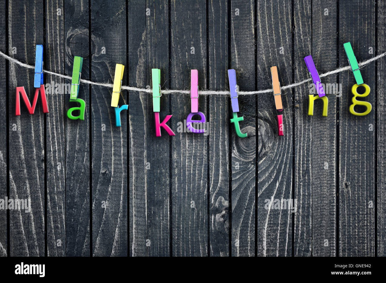 Marketing word hanging on clips and wooden wall Stock Photo - Alamy