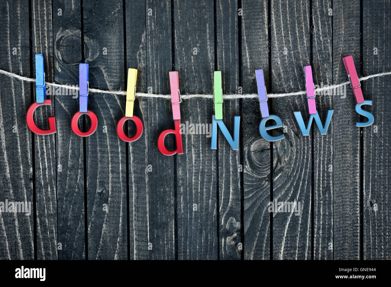 Good News word hanging on clips and wooden wall Stock Photo - Alamy
