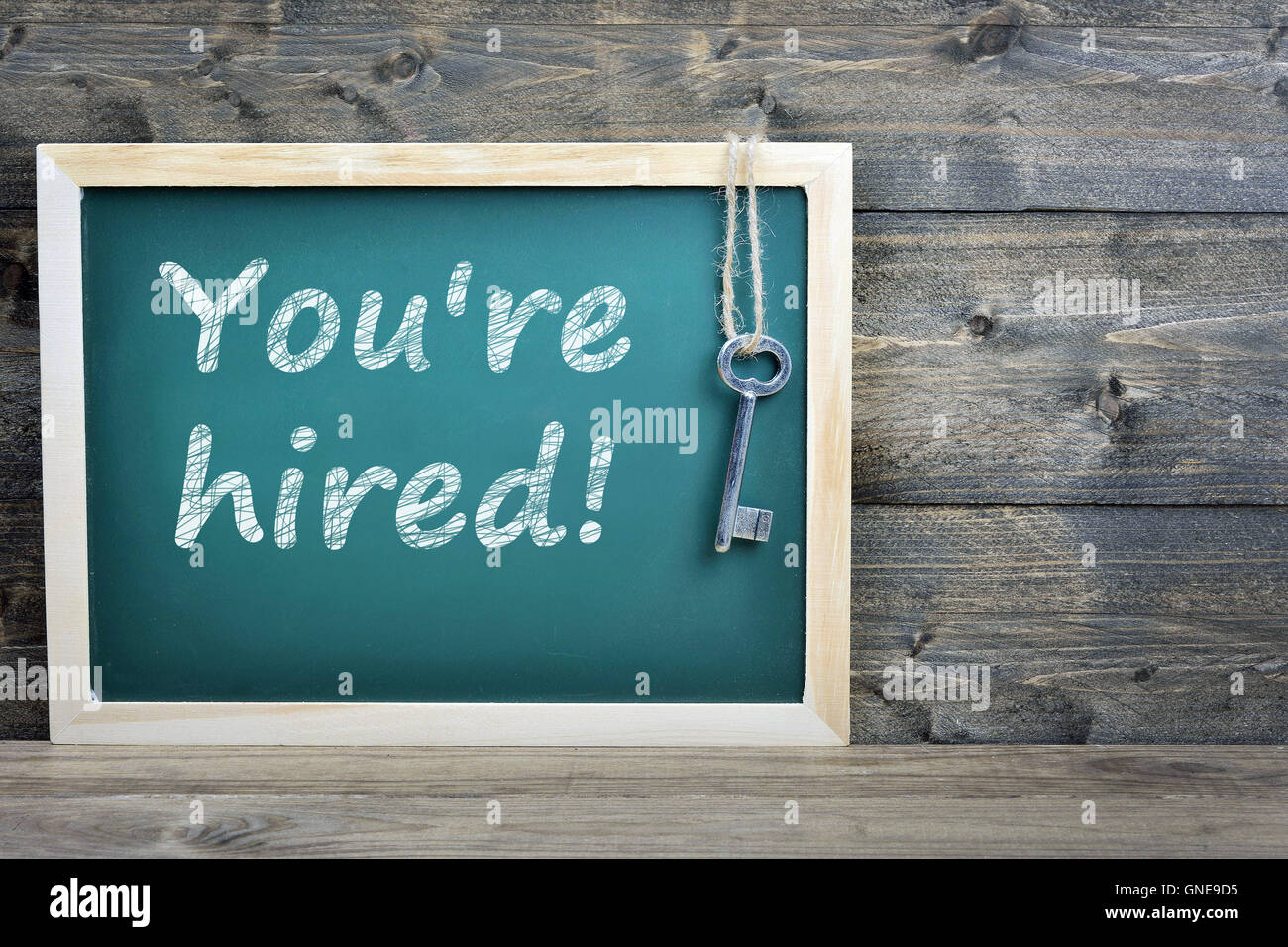 You're hired text on school board and old key Stock Photo - Alamy