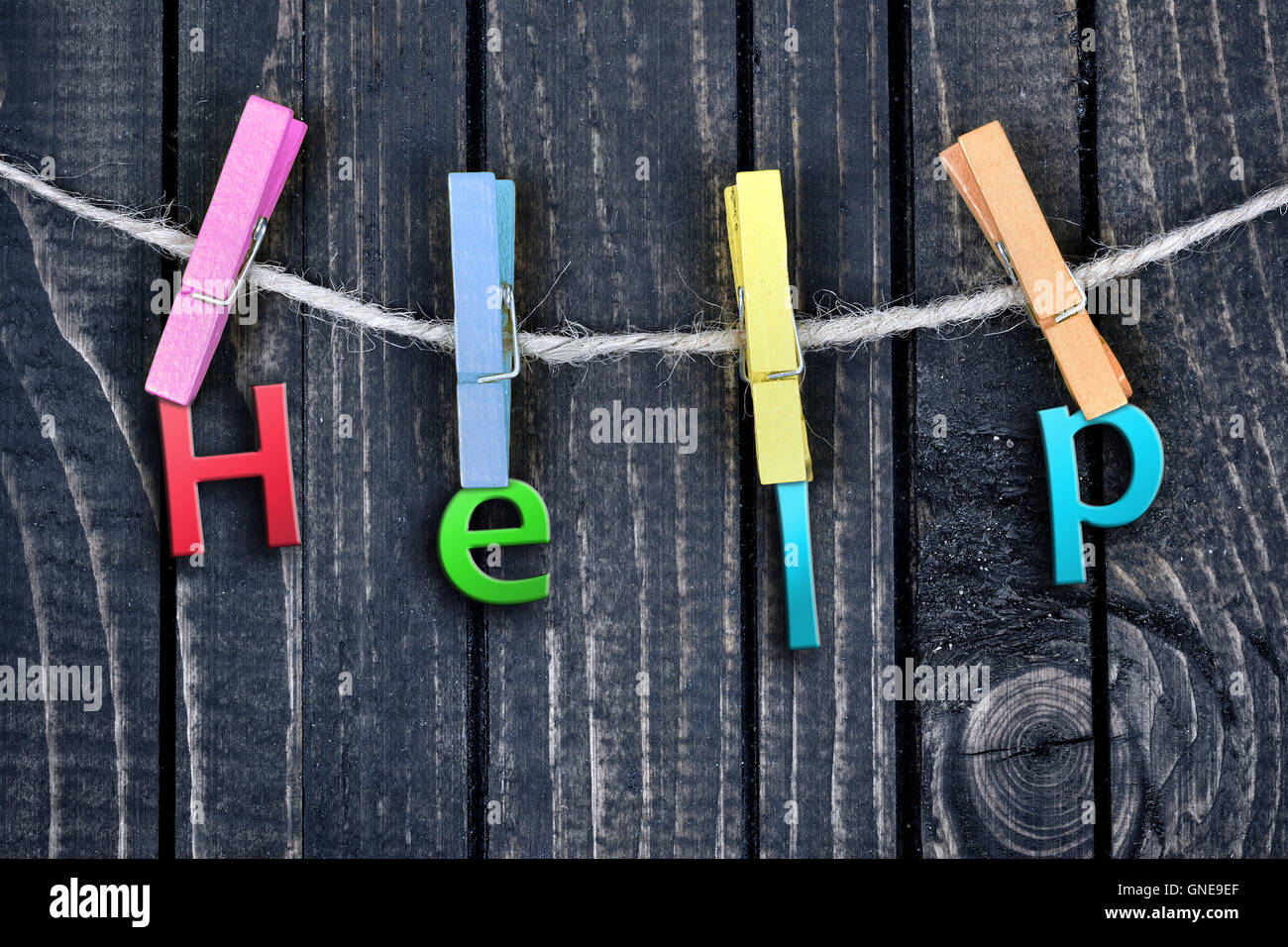 Help word hanging on clips and wooden wall Stock Photo - Alamy