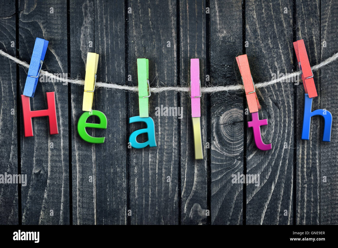 Health word hanging on clips and wooden wall Stock Photo - Alamy