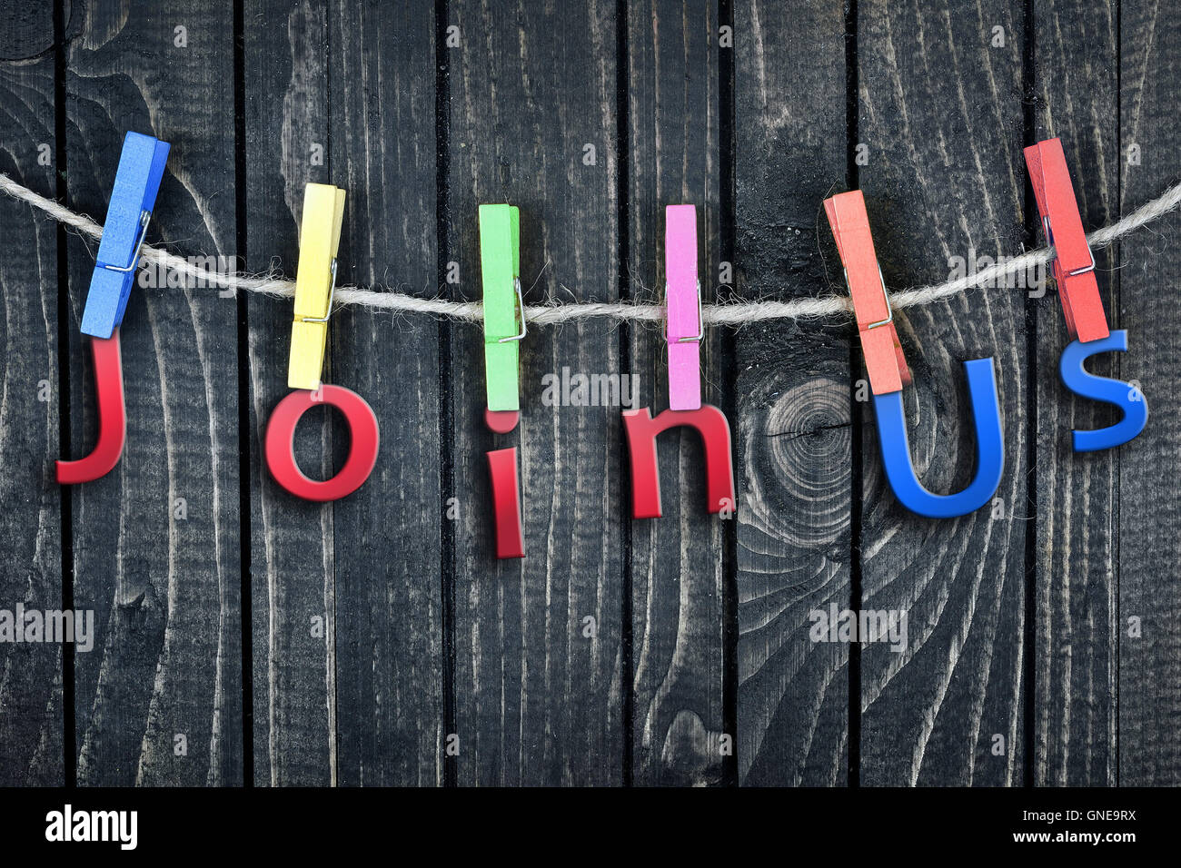 Join Us word hanging on clips and wooden wall Stock Photo - Alamy