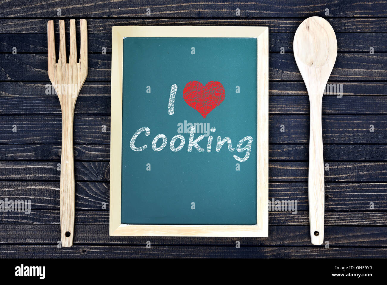 I love cooking text on green board with fork and spoon on wooden table ...