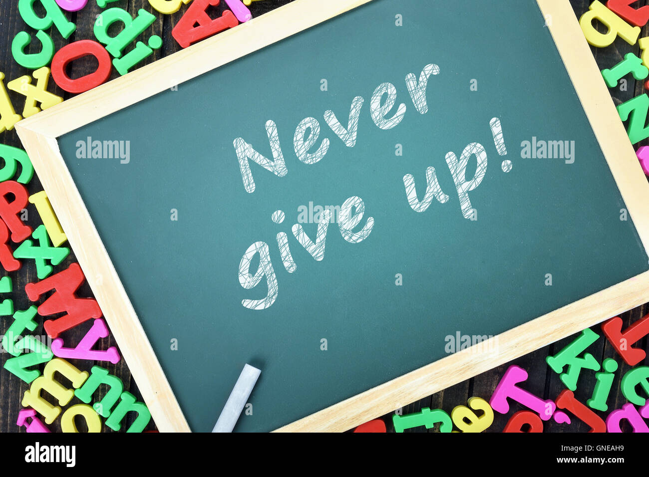 Never give up text on school board and magnetic letters Stock Photo - Alamy