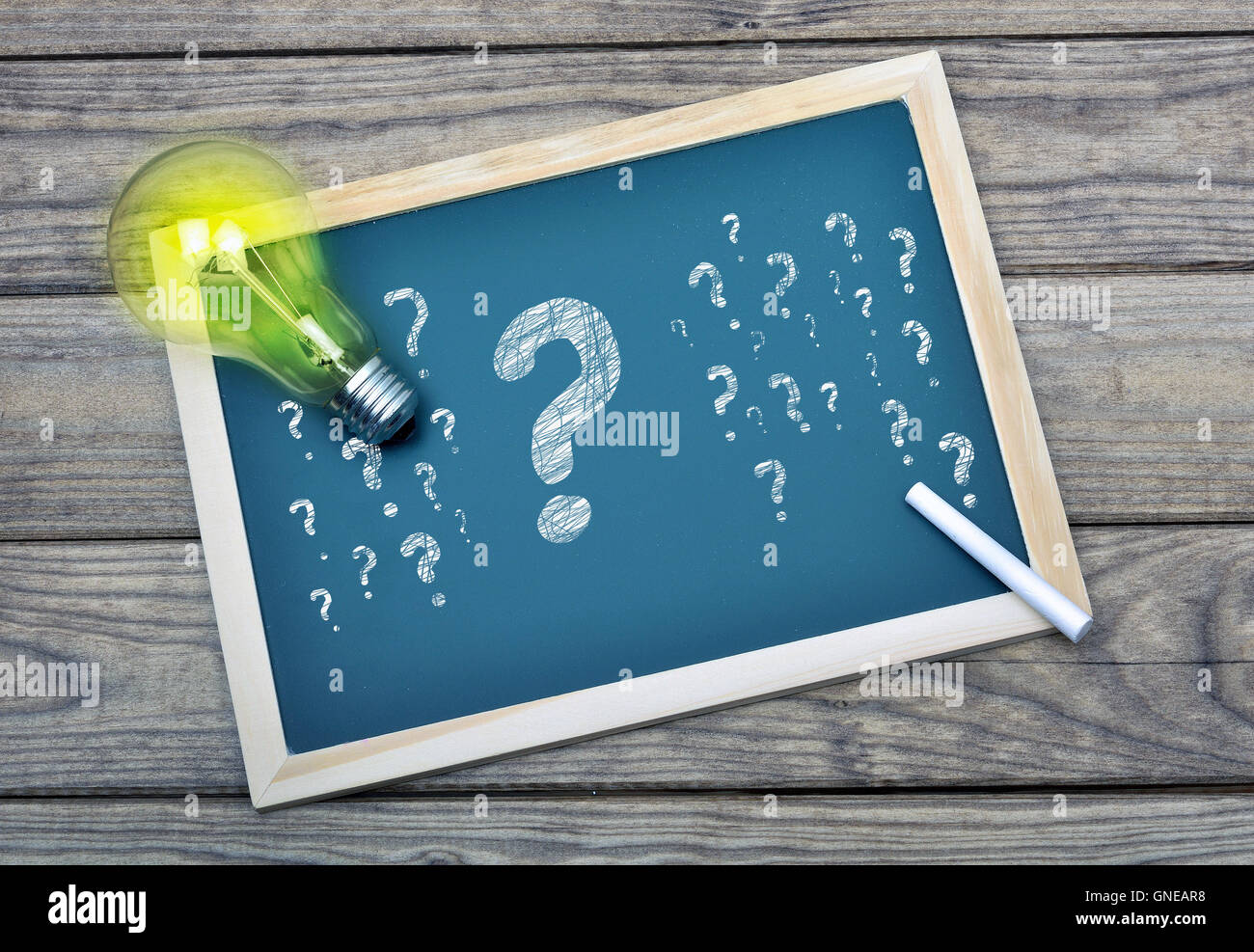 Question marks on school board and glowing light bulb Stock Photo - Alamy