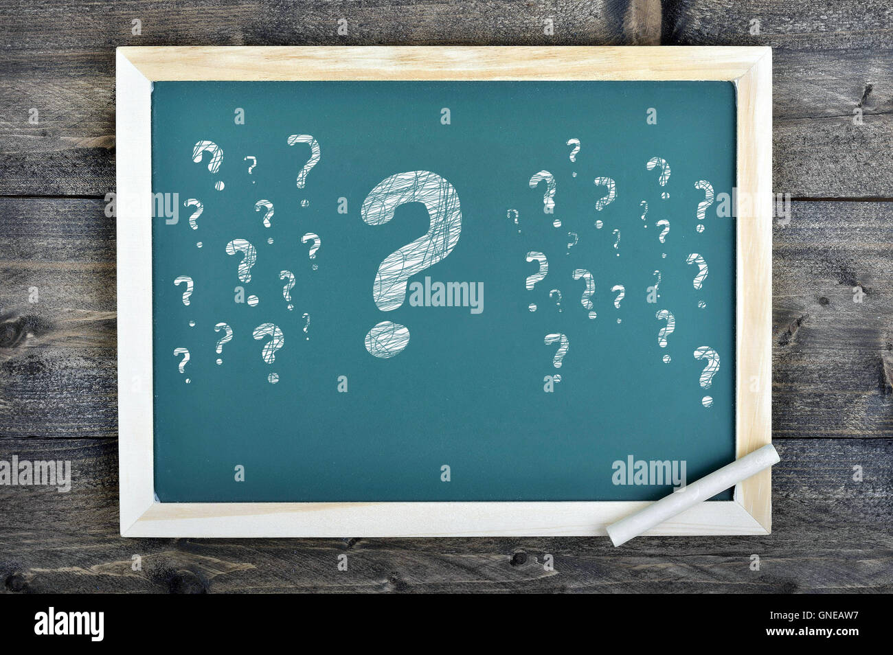 Question marks text on school board and chalk on wooden table Stock ...