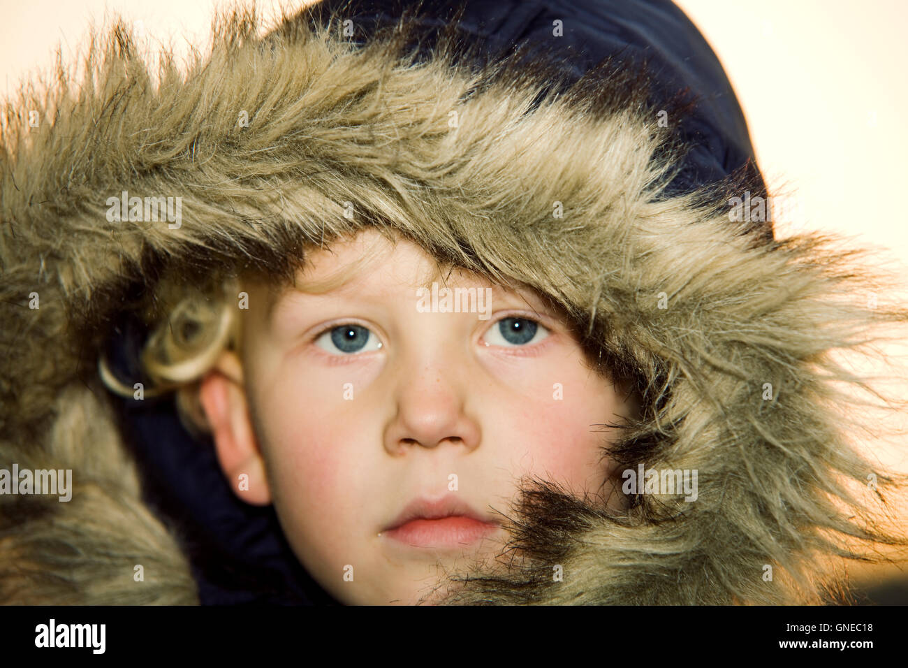 Little boy wearing a fur lined hood Stock Photo - Alamy