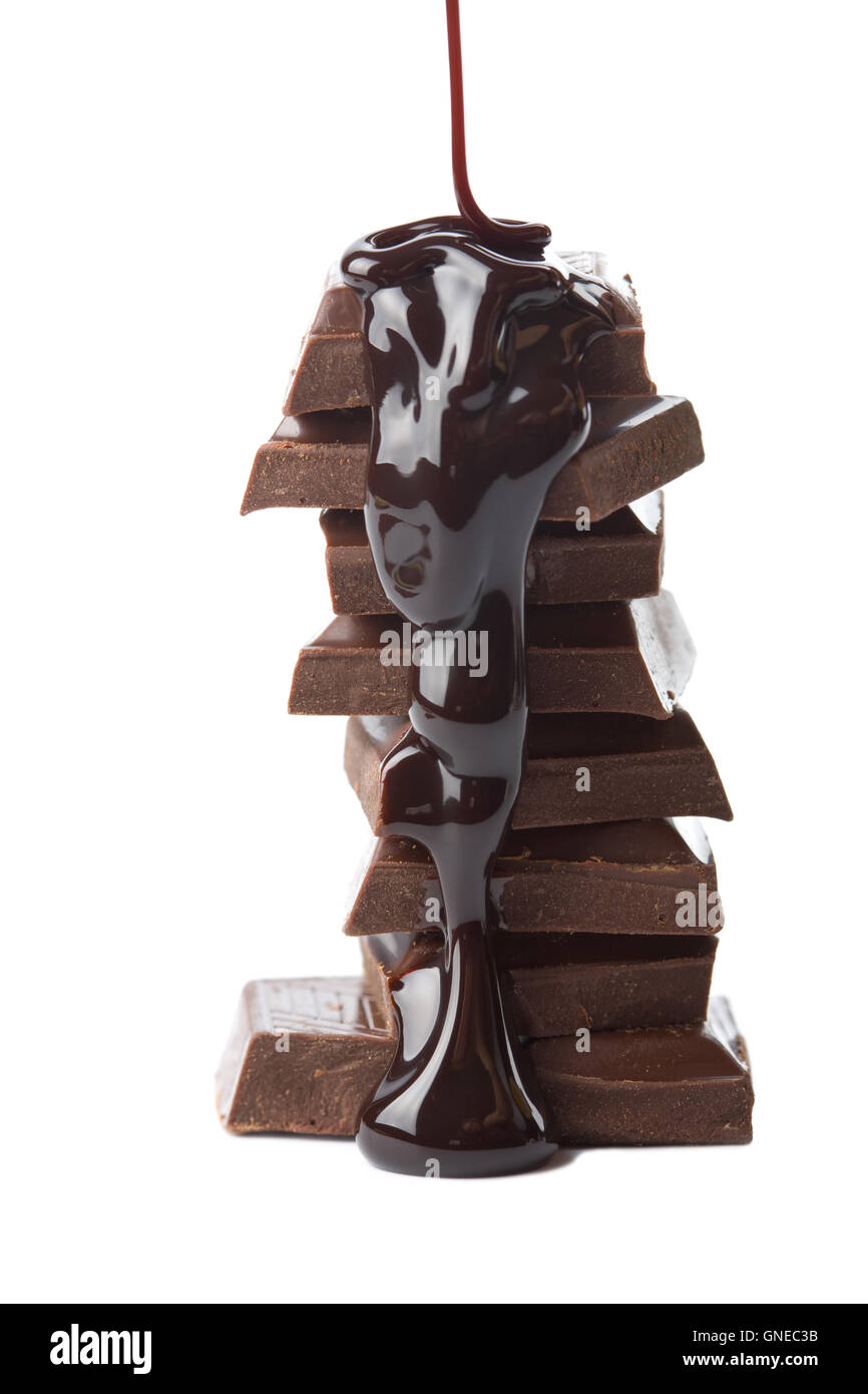 chocolate syrup being poured onto chocolate pieces isolated Stock Photo ...