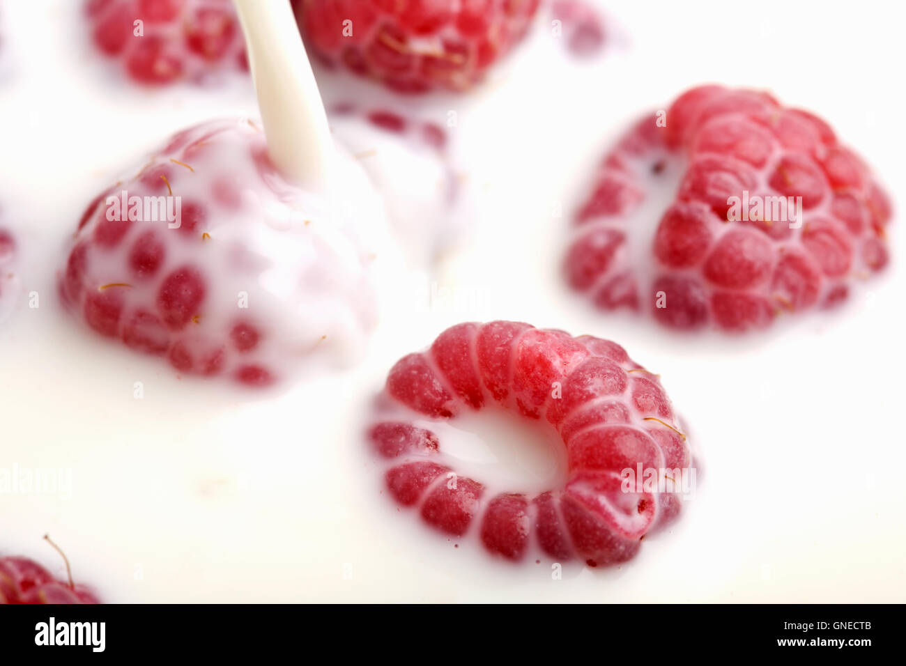 milk pouring onto fresh raspberries Stock Photo - Alamy