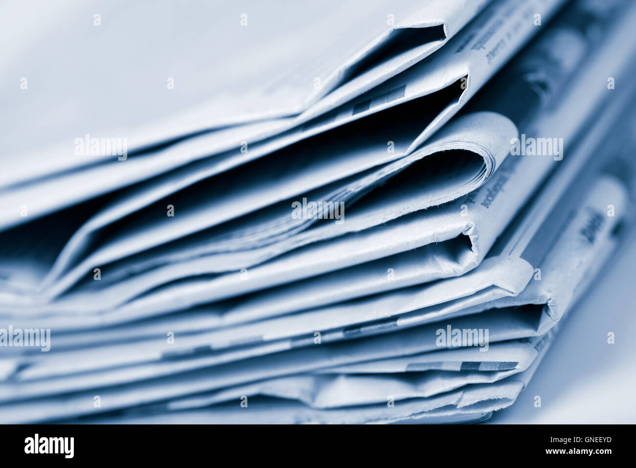 stack of newspapers toned blue Stock Photo - Alamy