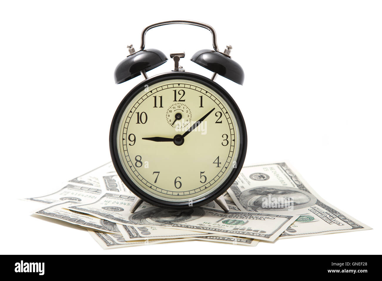 alarm clock over heap of money isolated Stock Photo - Alamy