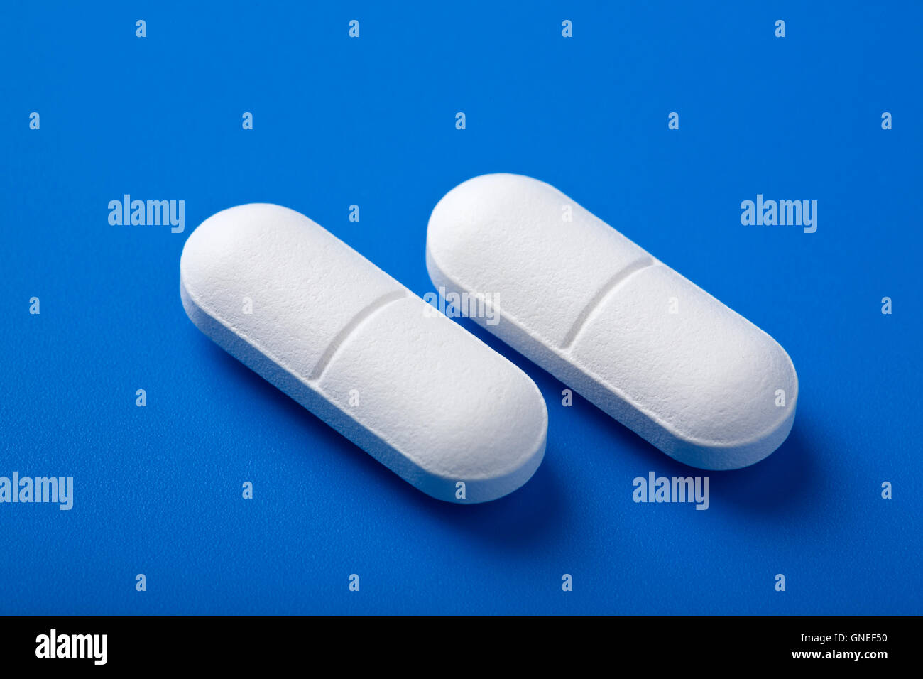 white pills over blue Stock Photo - Alamy