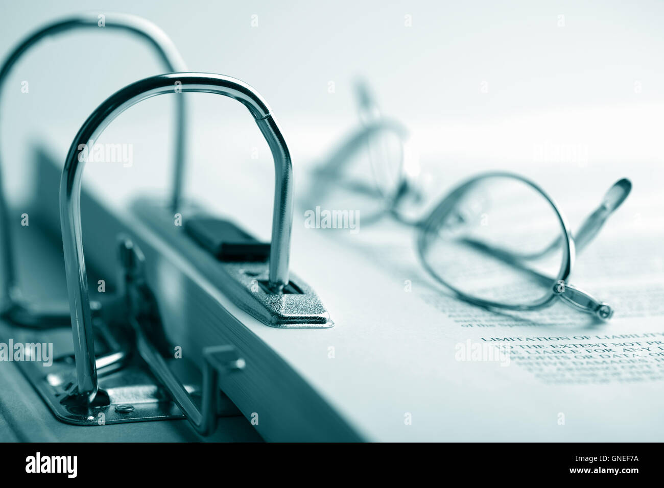 open binder and glasses over document toned blue Stock Photo - Alamy