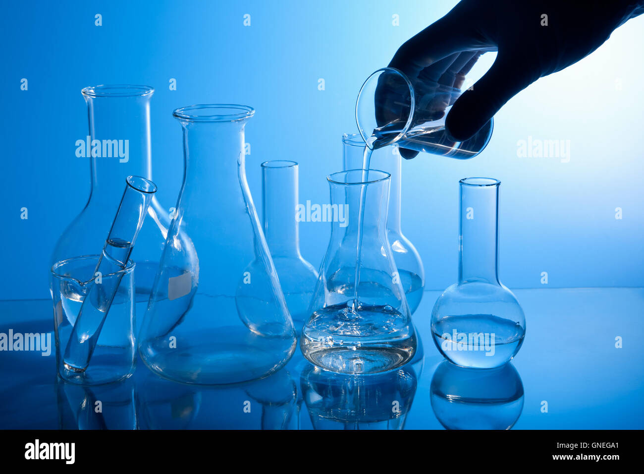 hand pouring liquid into flask Stock Photo - Alamy