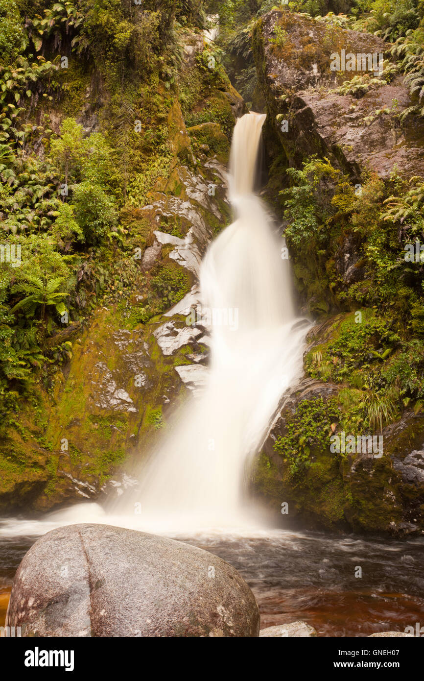 Silky forest waterfall cascading down rocky slope Stock Photo - Alamy