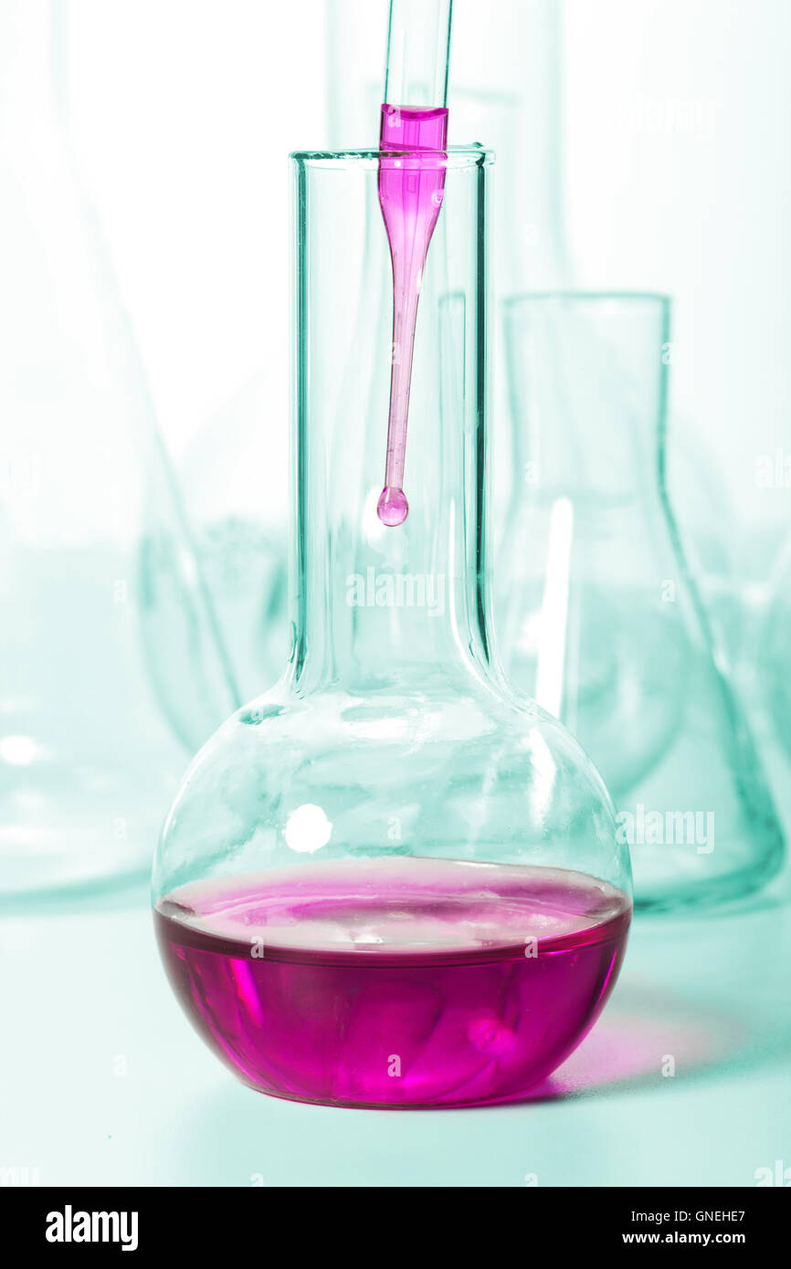 liquid dripping from pipette into flask Stock Photo - Alamy
