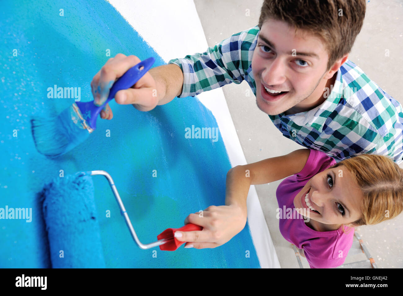 happy couple paint wall at new home Stock Photo - Alamy