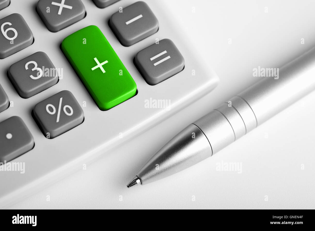 calculator and pen. plus button colored green Stock Photo - Alamy