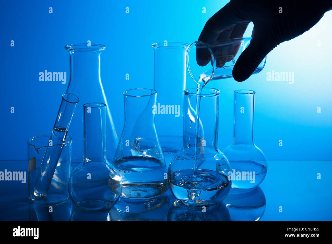 hand pouring liquid into flask Stock Photo - Alamy