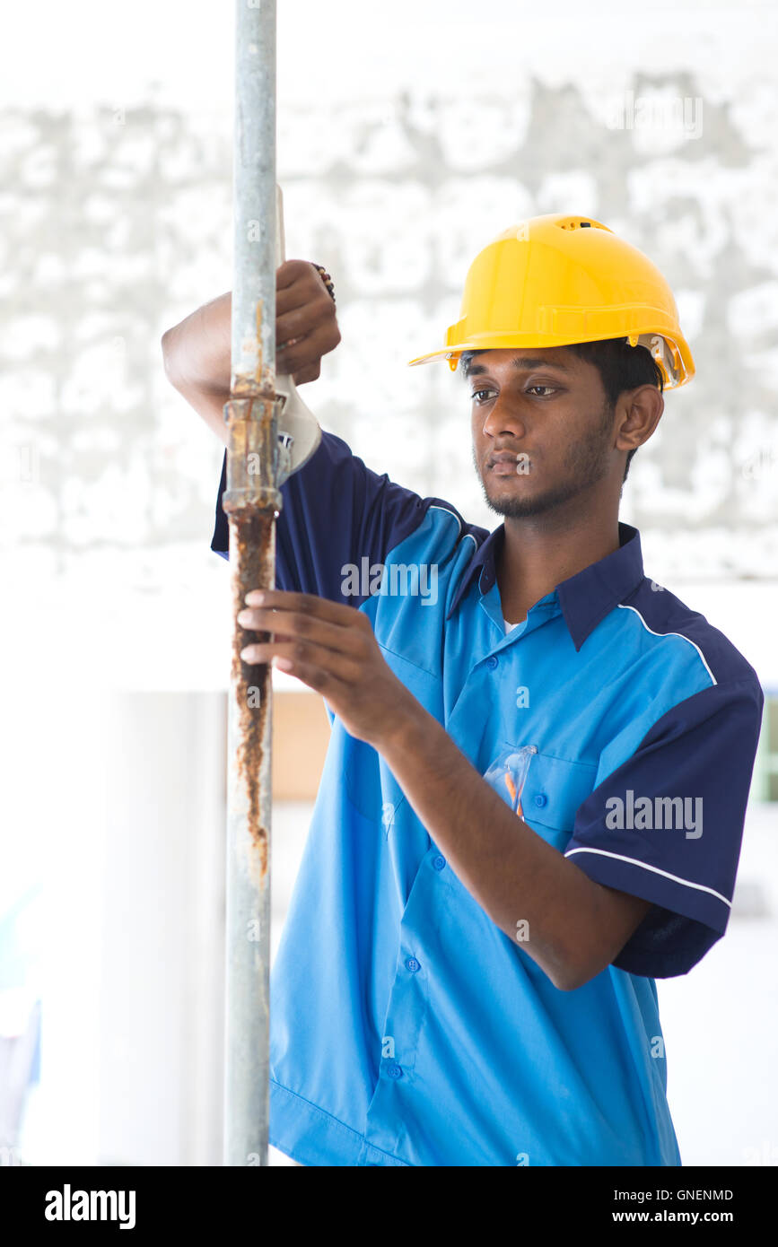 indian male plumber on site using hammer Stock Photo - Alamy