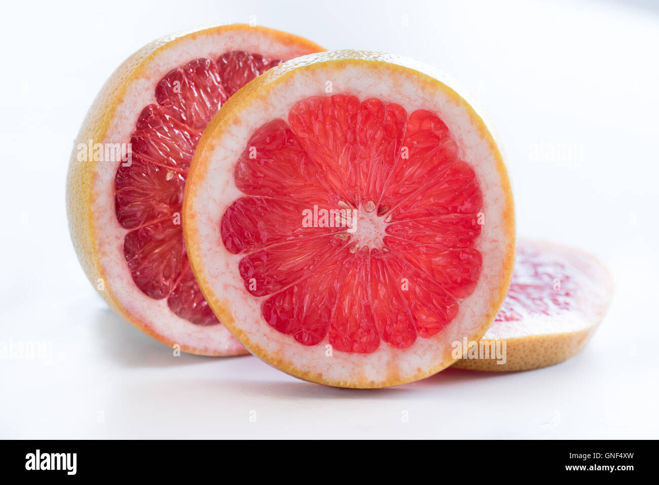 Slices of Ruby Grapefruit on white background Stock Photo - Alamy