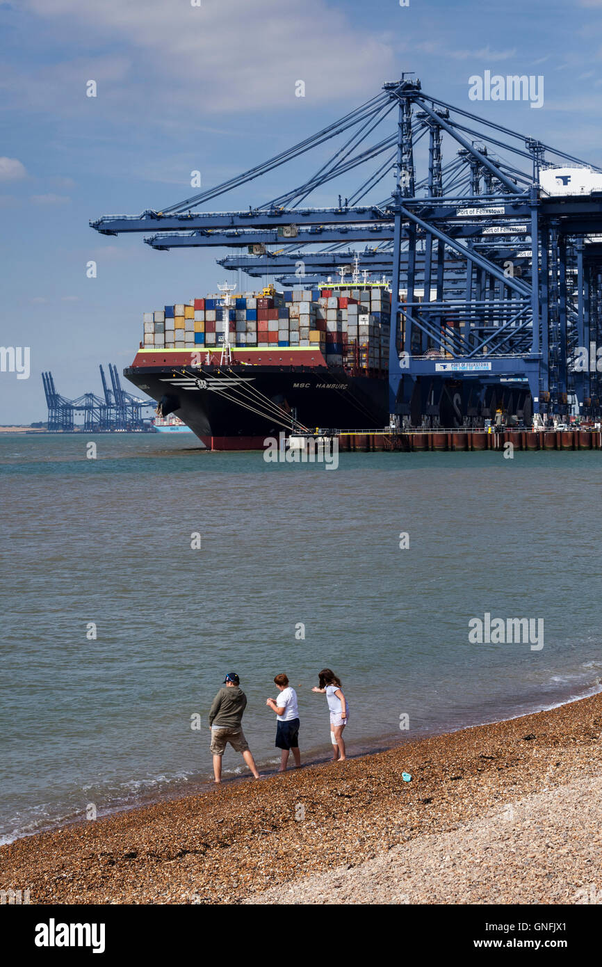 Youngsters on Beach Adjacent to Container Port with Ship Unloading in ...