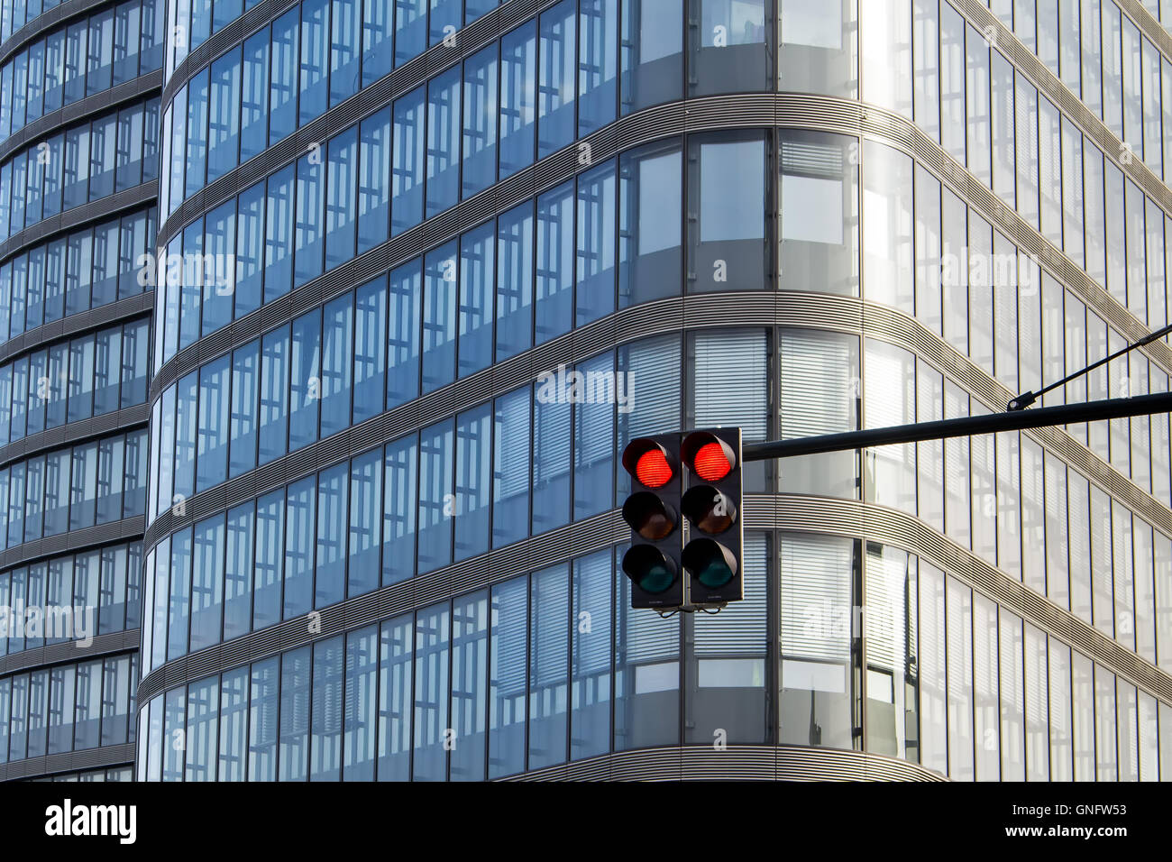 Double traffic lights with a red light. Texture of a modern building in ...
