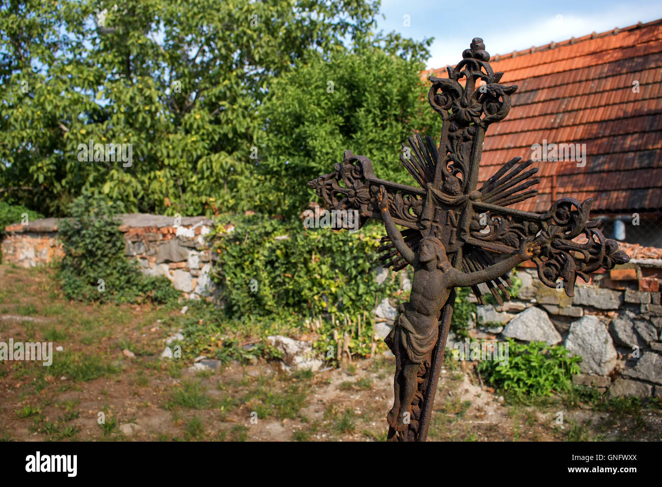 One of the first tombs on the cemetery, already rusted. Green tree and ...