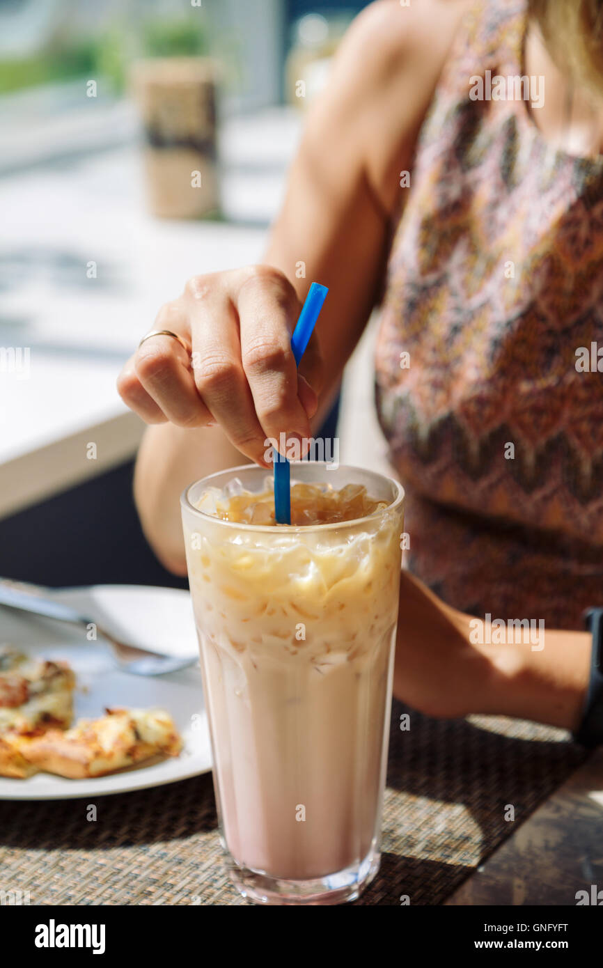 Female hand stirring cold drink in glass with straw Stock Photo - Alamy