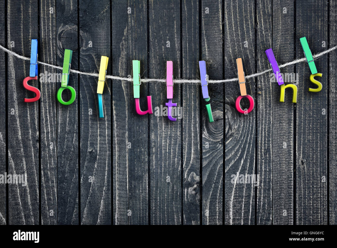Solutions word hanging on clips and wooden wall Stock Photo - Alamy