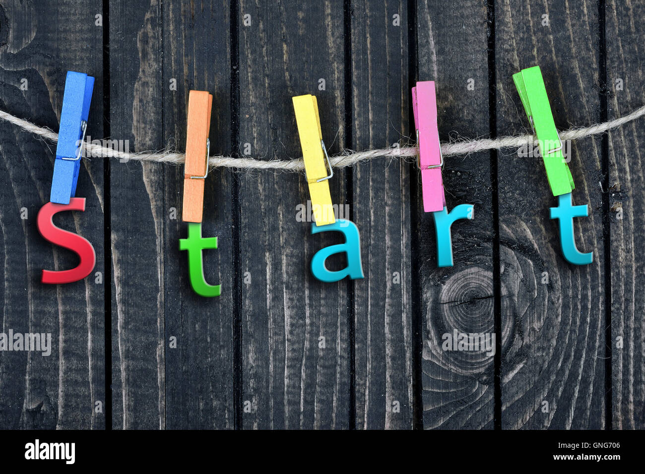 Start word hanging on clips and wooden wall Stock Photo - Alamy