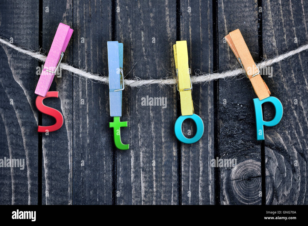Stop word hanging on clips and wooden wall Stock Photo - Alamy