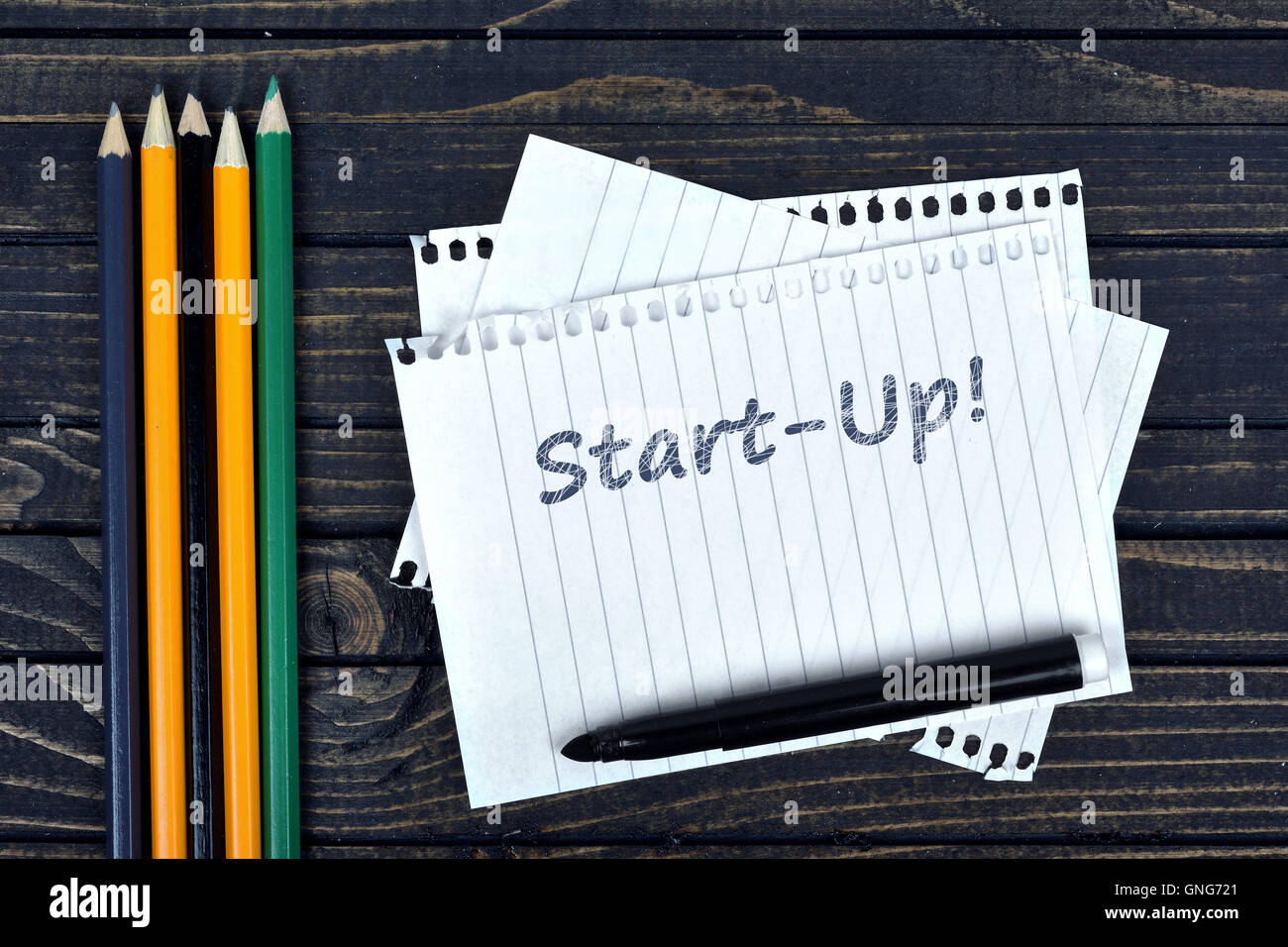 Start-up text on notepad and office tools on wooden table Stock Photo ...